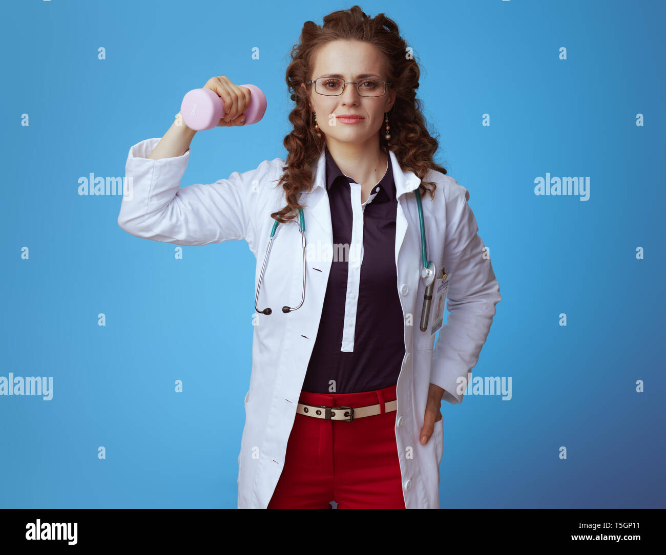 elegant medical doctor woman in bue shirt, red pants and white medical ...