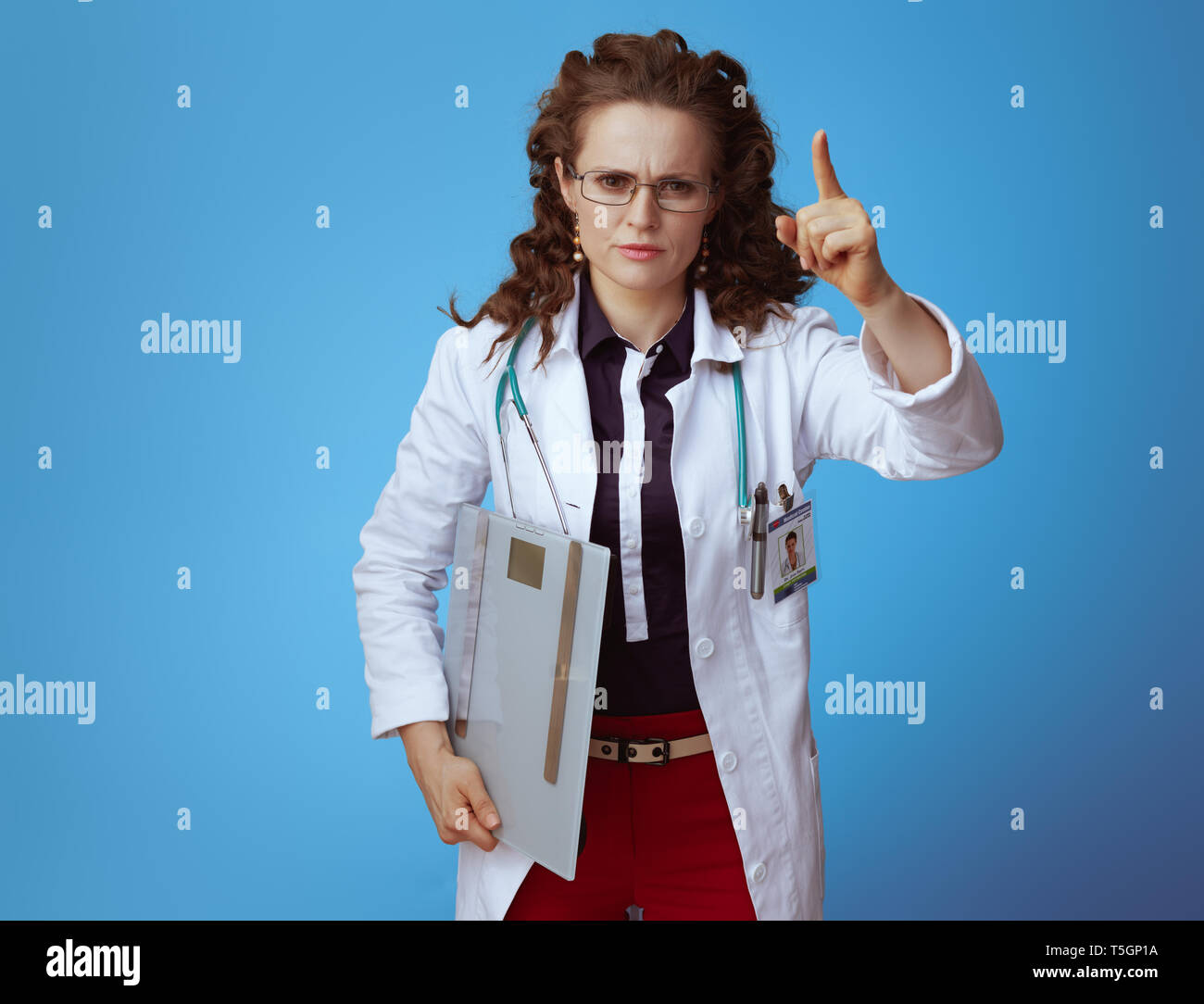 happy elegant doctor woman in bue shirt, red pants and white medical ...