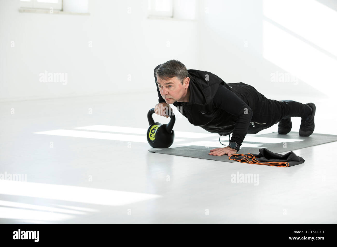 Man doing his fitness regime, doing kettle bell push-ups Stock Photo ...