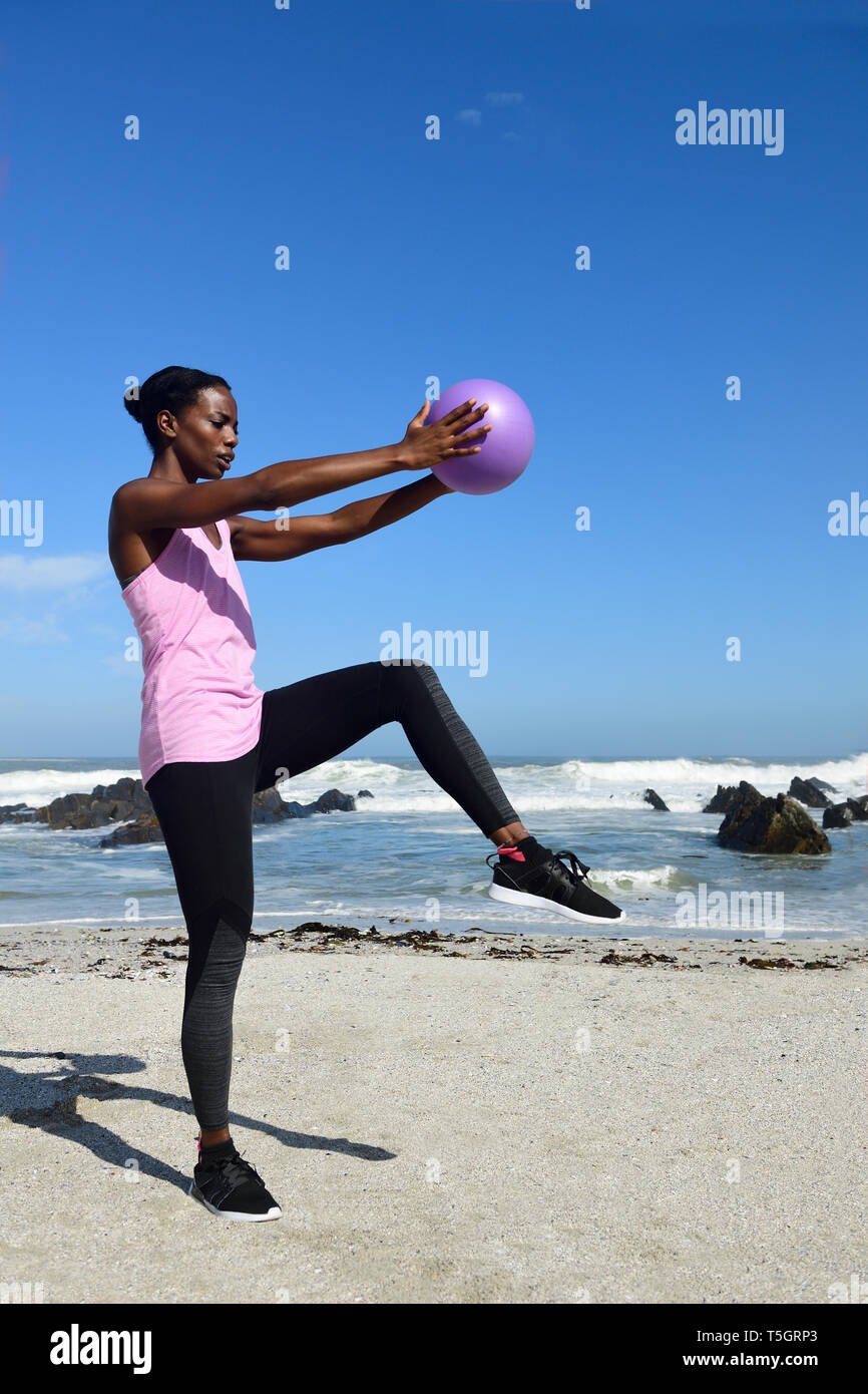 Woman doing fitness exercise with ball on the beach Stock Photo - Alamy