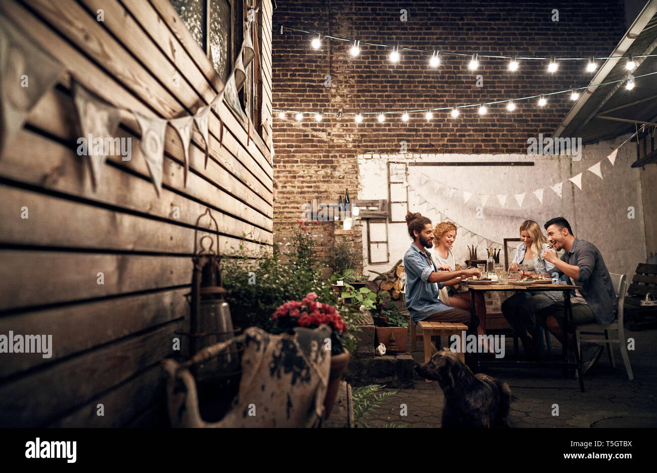 Friends having a barbecue in the backyard, eating together Stock Photo ...