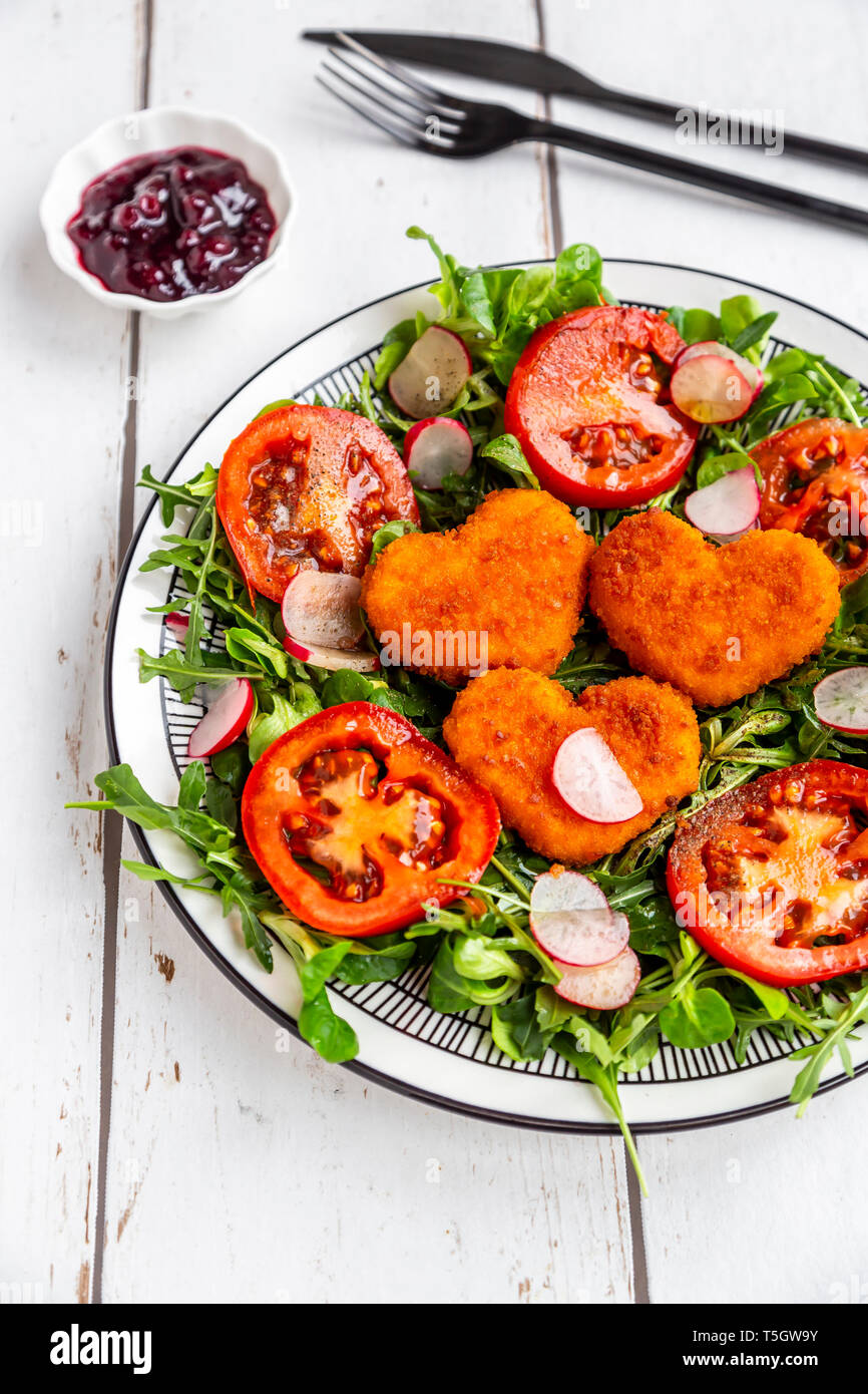 Baked camembert in heart shape with rocket, lamb's lettuce, tomato ...