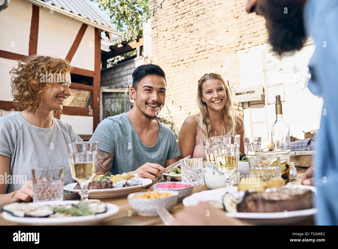 Friends having fun at a barbecue party, eating together Stock Photo - Alamy