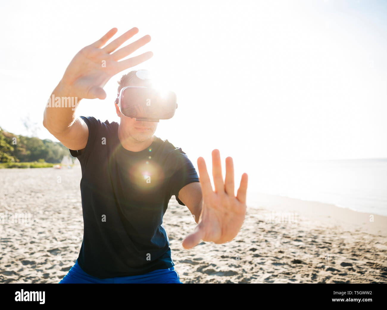 Man wearing VR glasses on the beach Stock Photo - Alamy