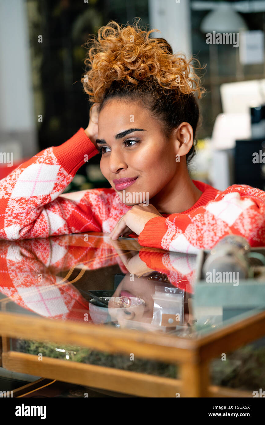 Young woman working in fashion store, leaning on counter Stock Photo ...