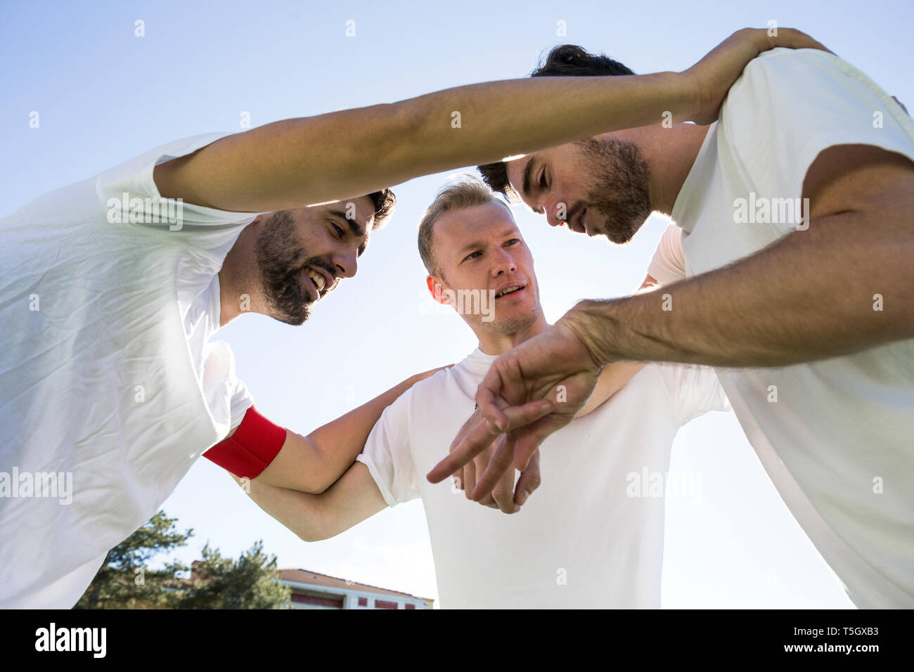 Football players discussing strategy on football field Stock Photo - Alamy