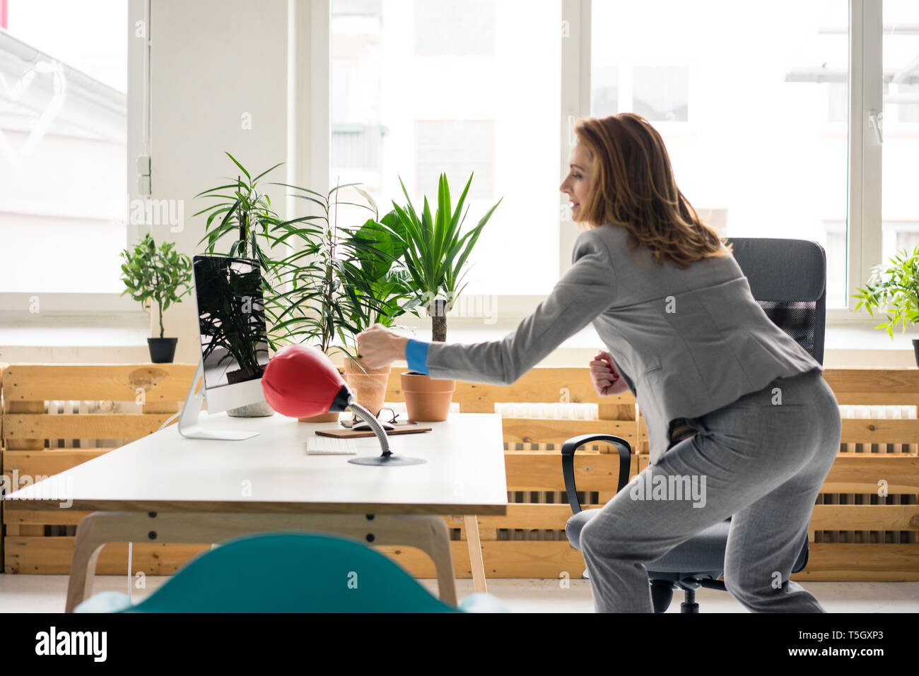 Businesswoman boxing a punchingball in her office Stock Photo - Alamy