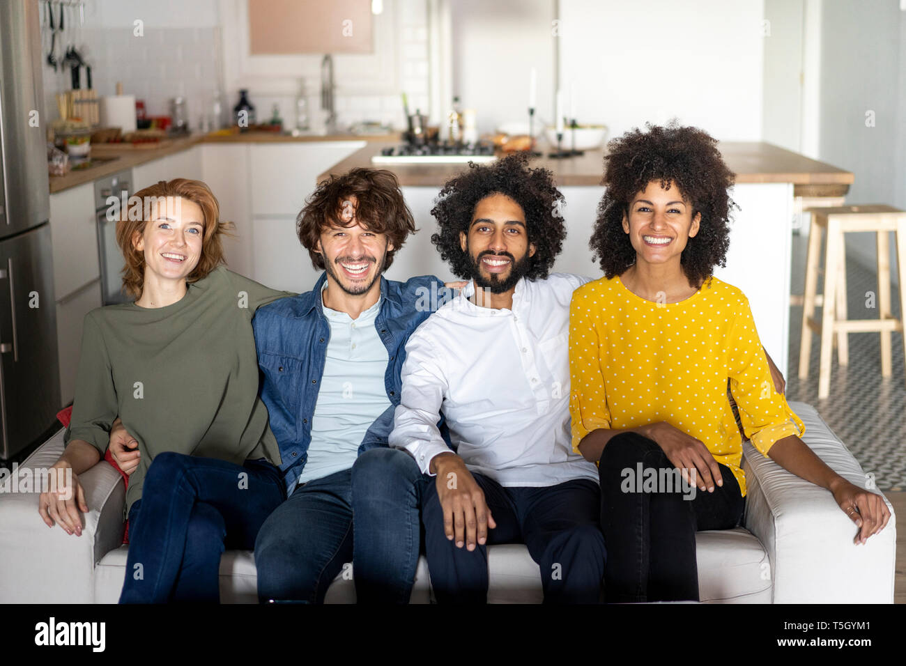 Friends meeting at home, sitting on couch, laughing Stock Photo - Alamy