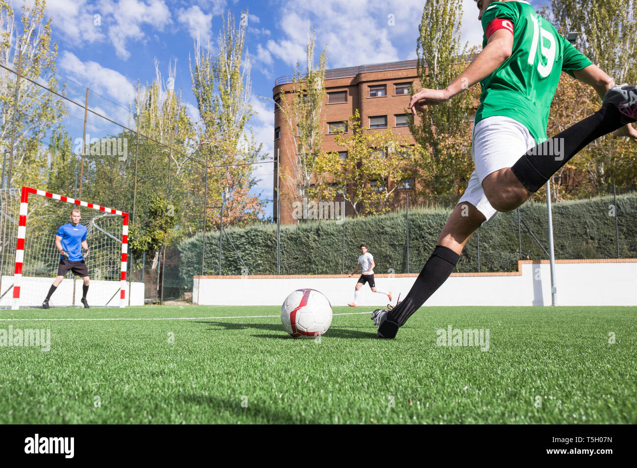 Football player shooting the ball on football field Stock Photo - Alamy