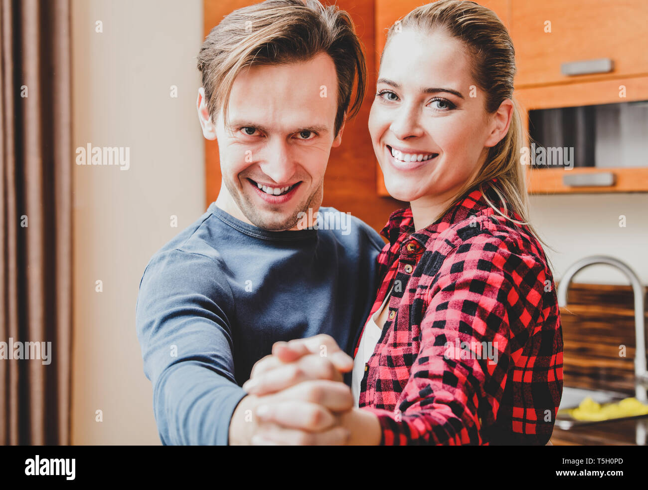Front view of young married couple dancing in home. Together leisure ...