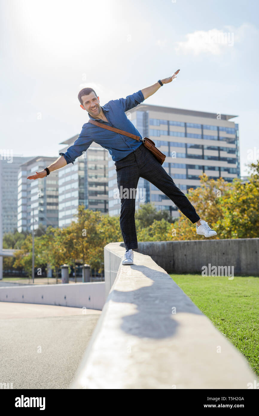 Portrait of man balancing on wall Stock Photo - Alamy