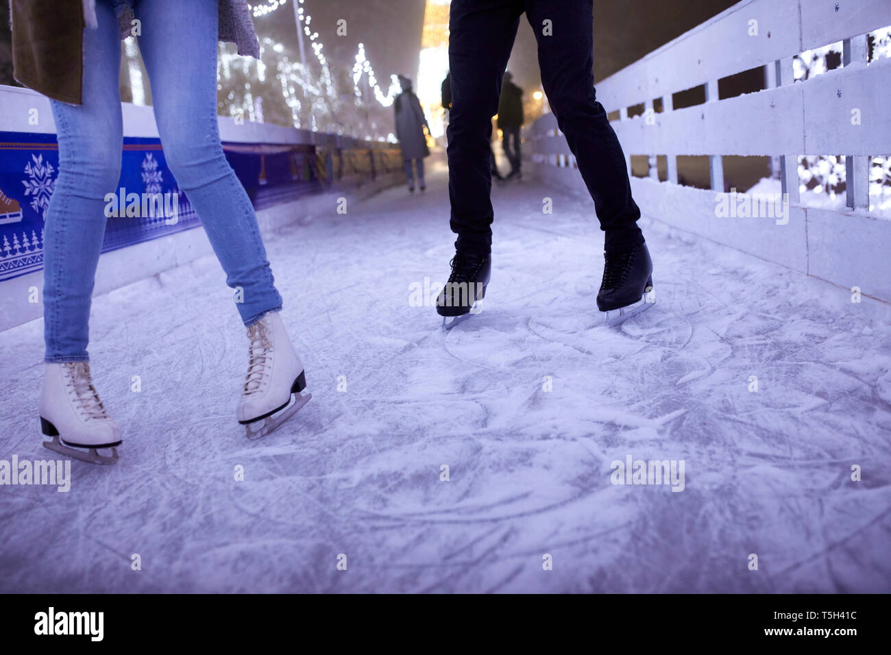 Legs of couple ice skating on an ice rink at night Stock Photo - Alamy