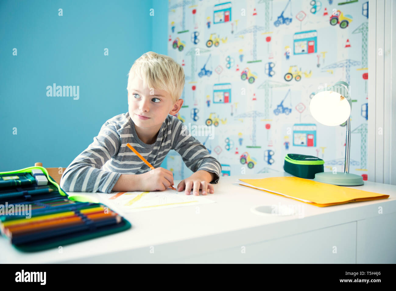 Boy doing homework at desk in children's room Stock Photo - Alamy