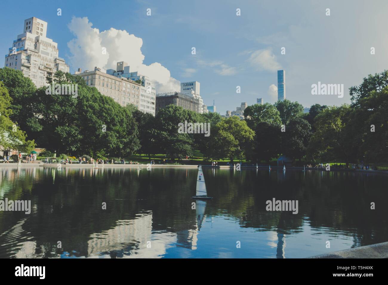 A reflecting lake in a park with tall buildings and beautiful sky Stock ...