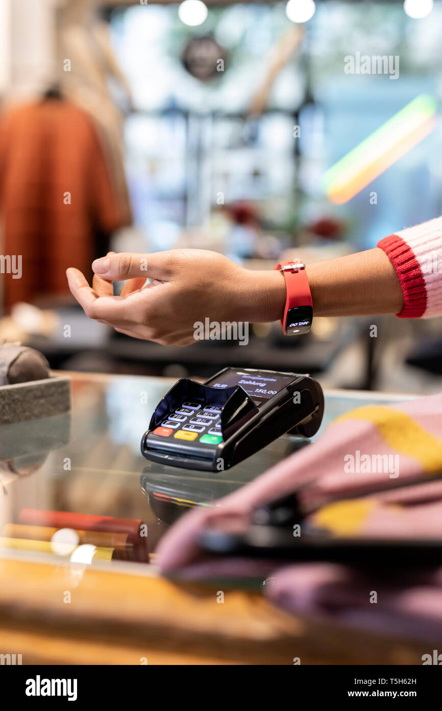 Customer paying contactless with her smartwatch Stock Photo - Alamy