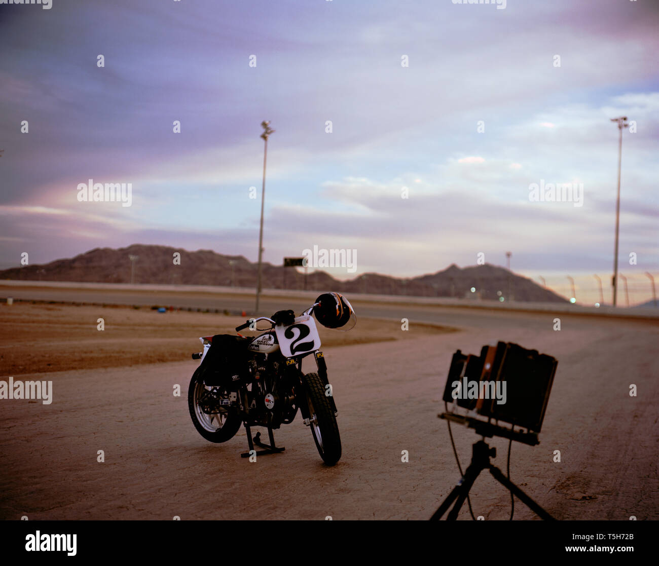 Lone motorcycle and helmet on an empty dirt race track Stock Photo - Alamy