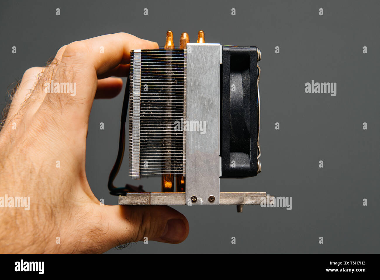 Man holding dusty dirty computer CPU heatsink cooler of a server ...
