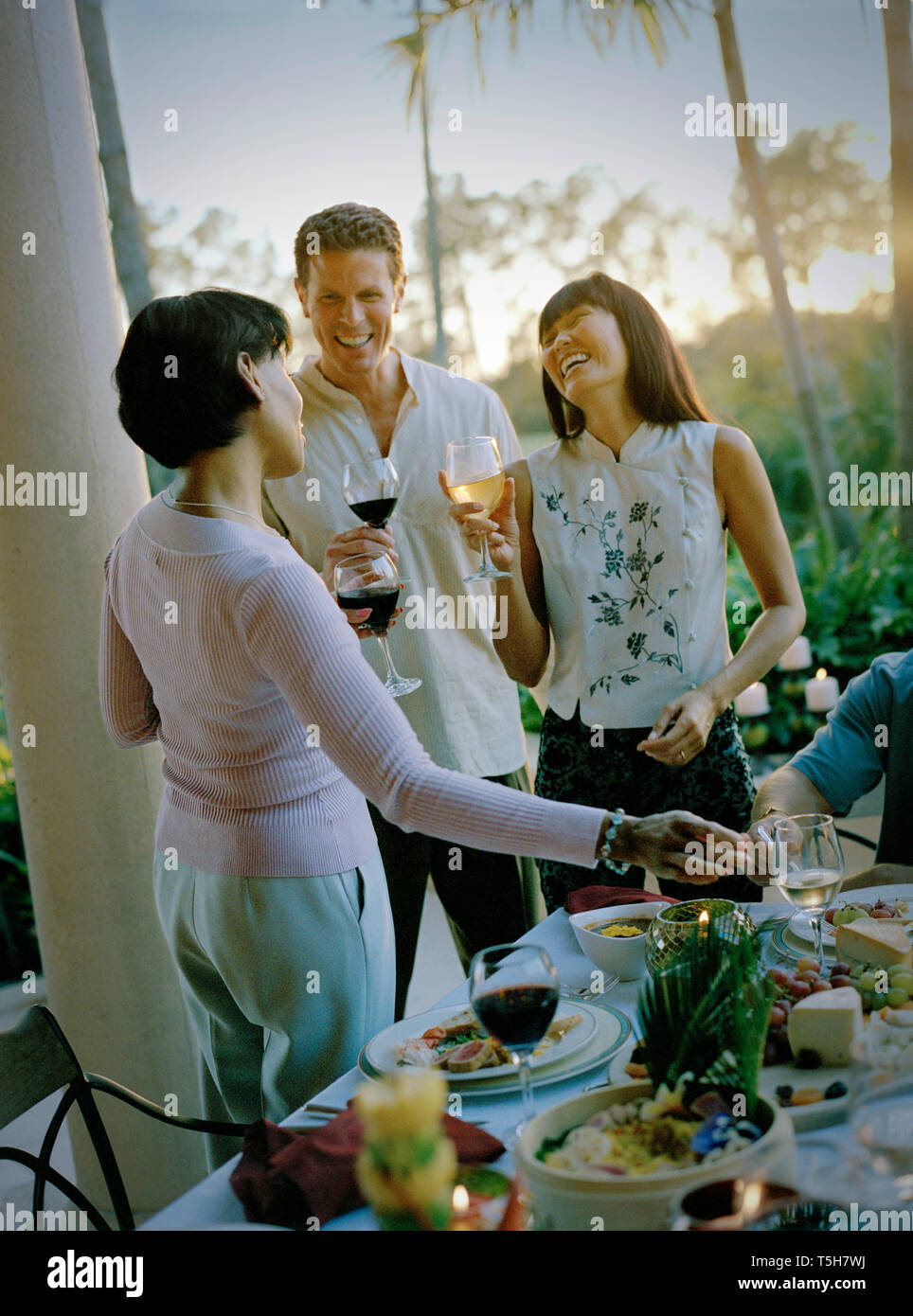 Man and two women laughing together during dinner party Stock Photo - Alamy