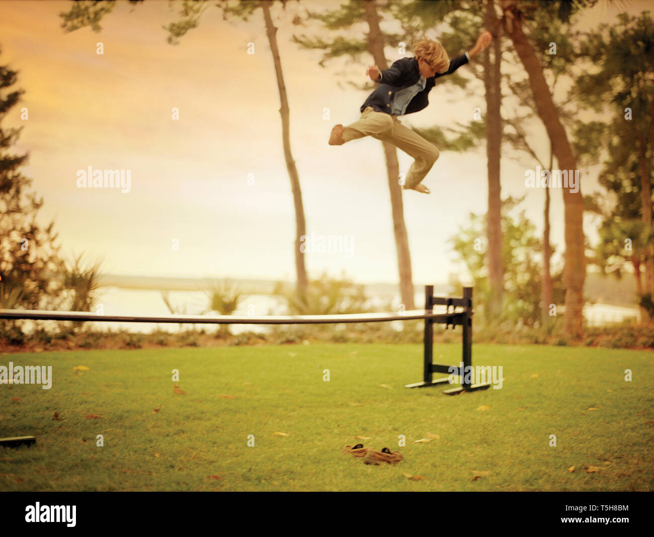 A boy jumping in a field Stock Photo - Alamy
