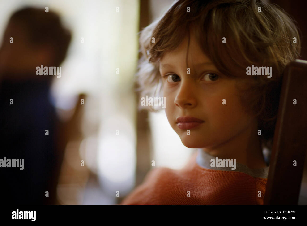 little boy with blurred people in background Stock Photo - Alamy