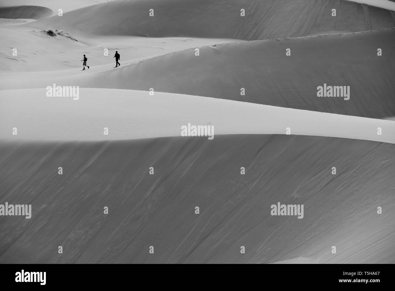 Small Man Hiking on Sand Dunes Stock Photo - Alamy