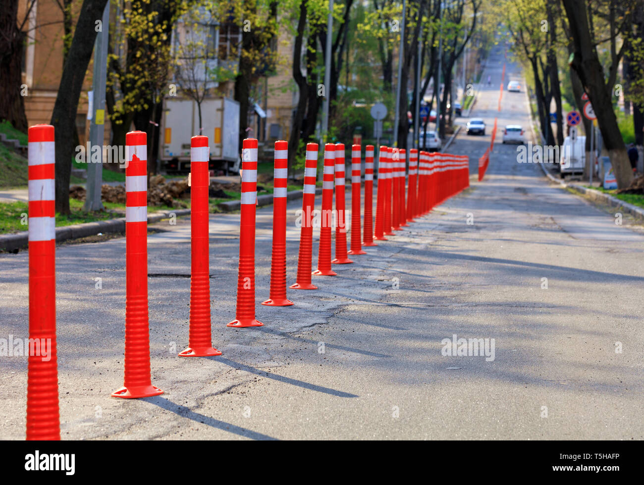 Red reflective road columns divide a bad road in half against the ...