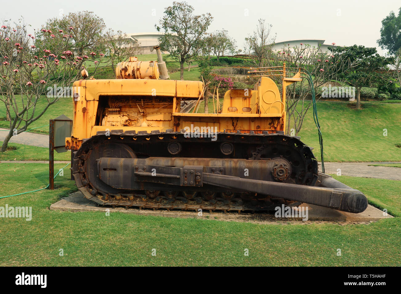 Old yellow rusty crawler tractor in the field. Old crawler tractor on ...