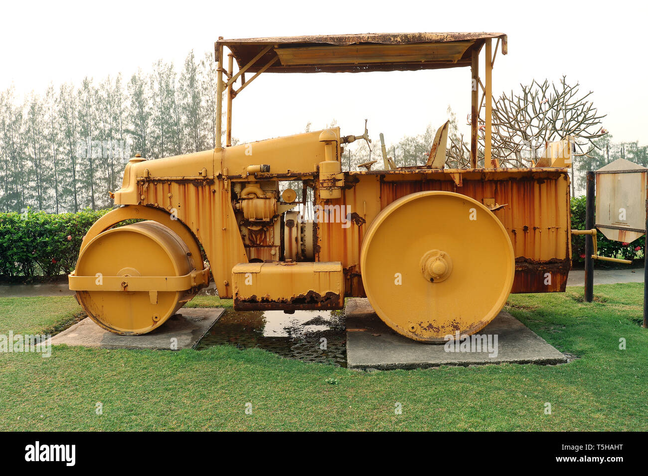 old roller compactor machine with yellow color on green garden High ...
