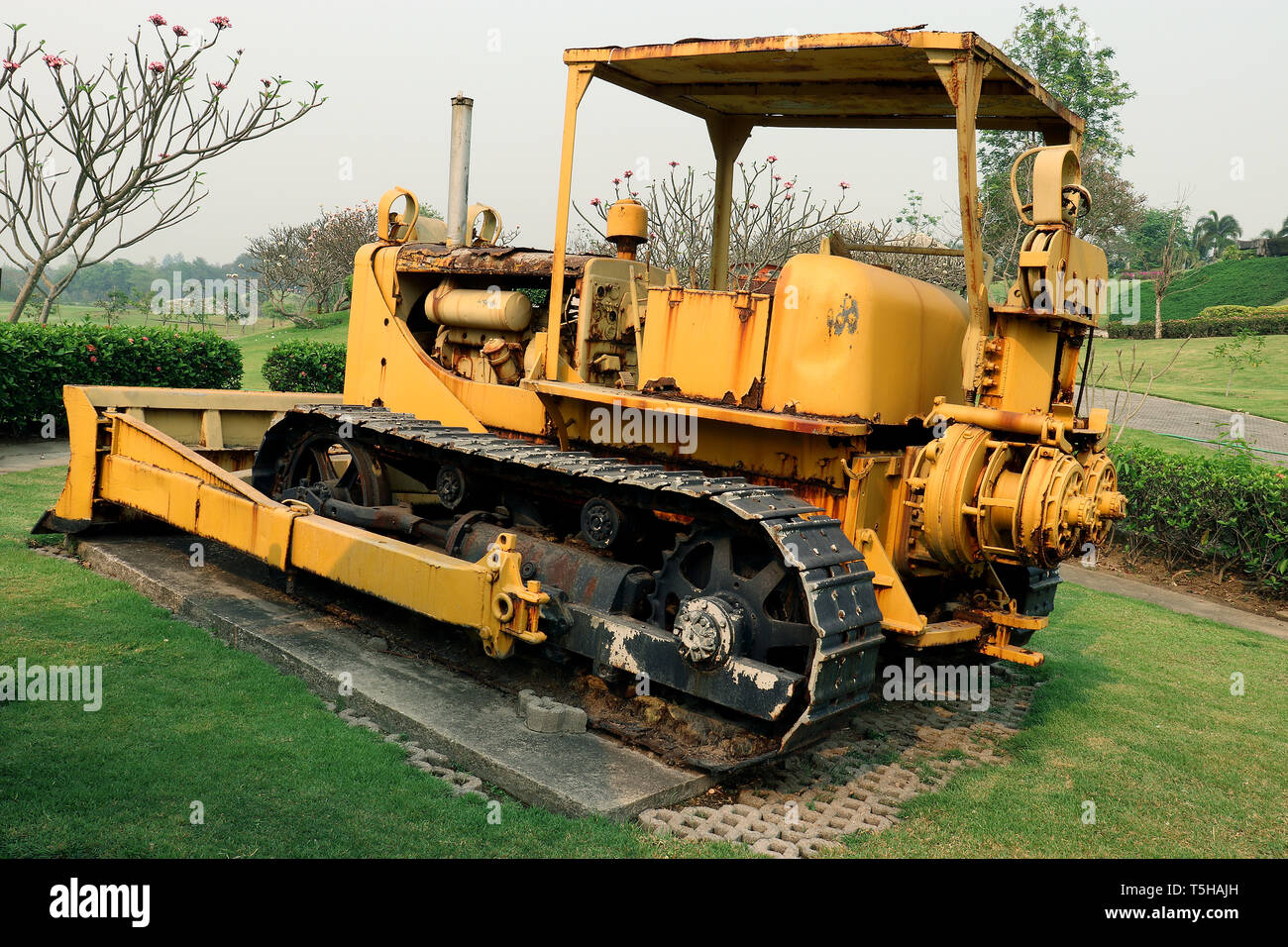 Old yellow rusty crawler tractor in the field. Old crawler tractor on ...