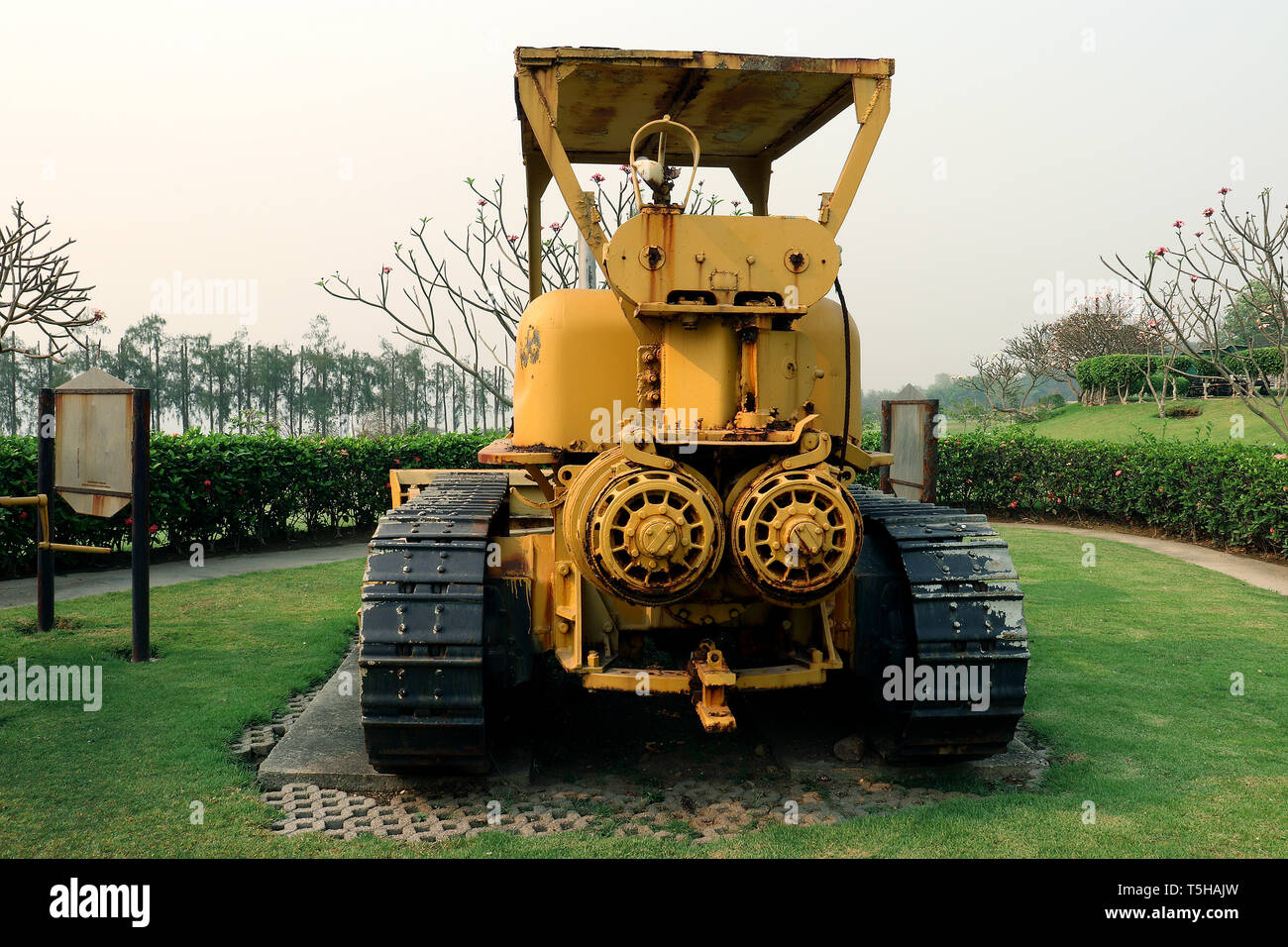 Old yellow rusty crawler tractor in the field. Old crawler tractor on ...