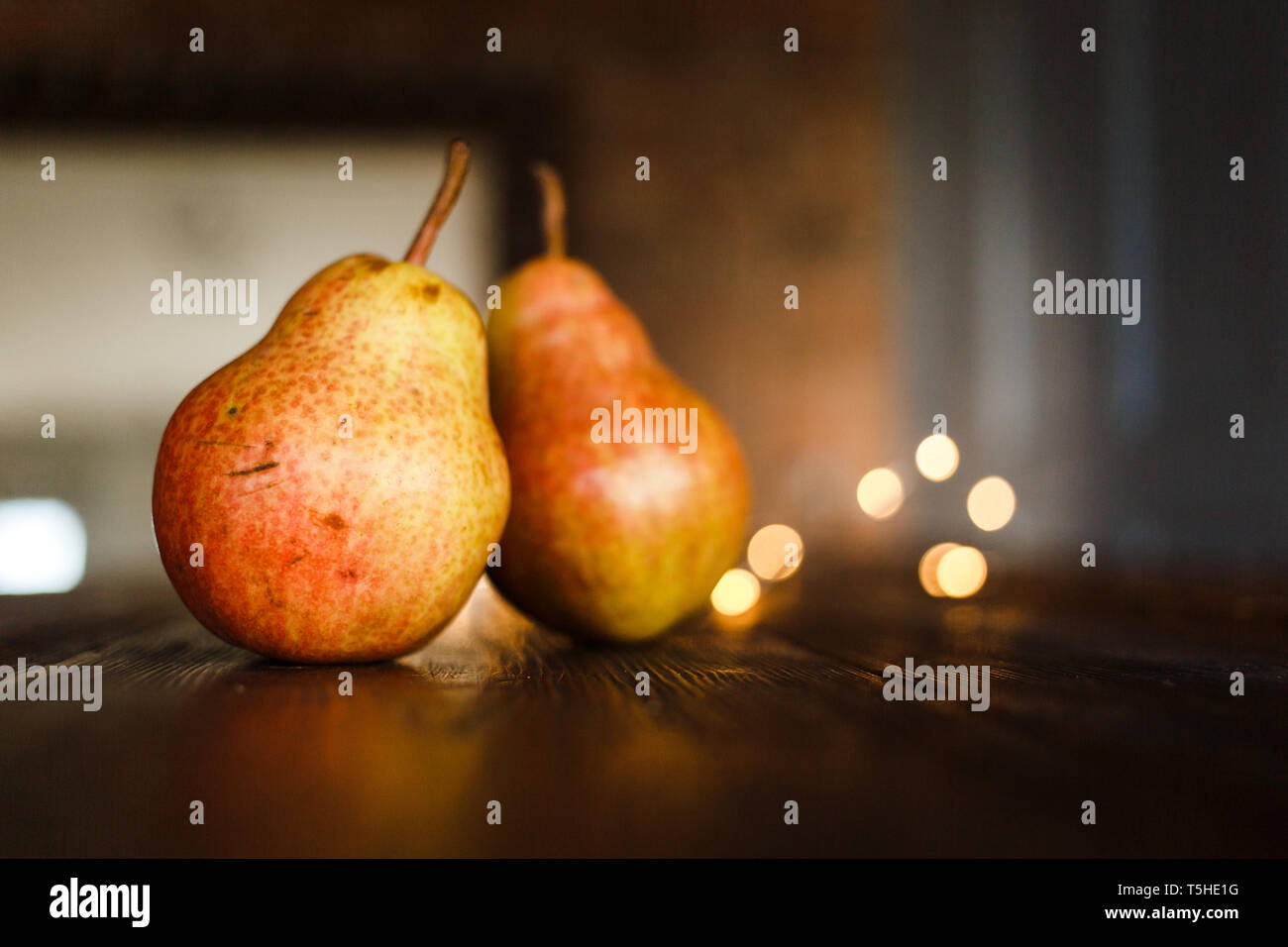 Beautiful ripe tasty pears on a large kitchen wooden table with a ...