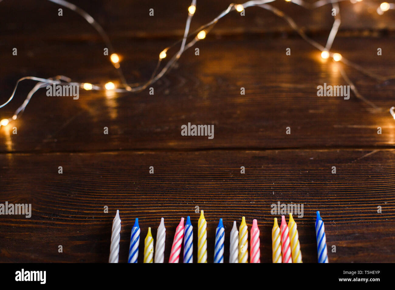 Garland of lights and candles for the cake on a dark wooden background ...