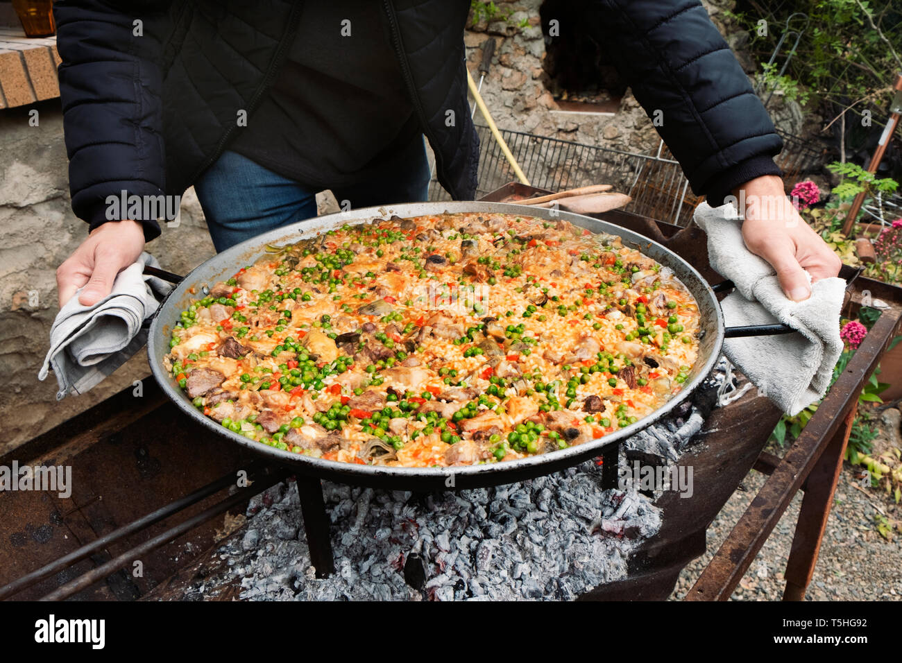 closeup of a young caucasian man with a typical spanish paella, cooked ...