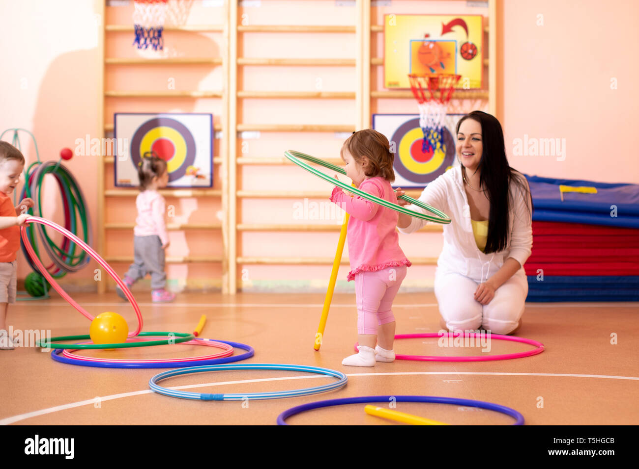 Kids group with colorful hula hoops in gym Stock Photo - Alamy