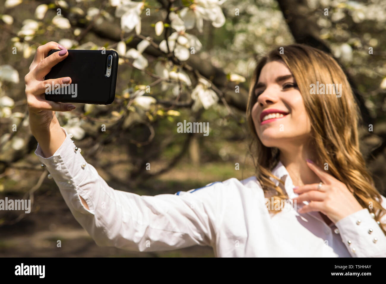 Young Beautiful Caucasian Girl Makes Selfie On A Smartphone Among