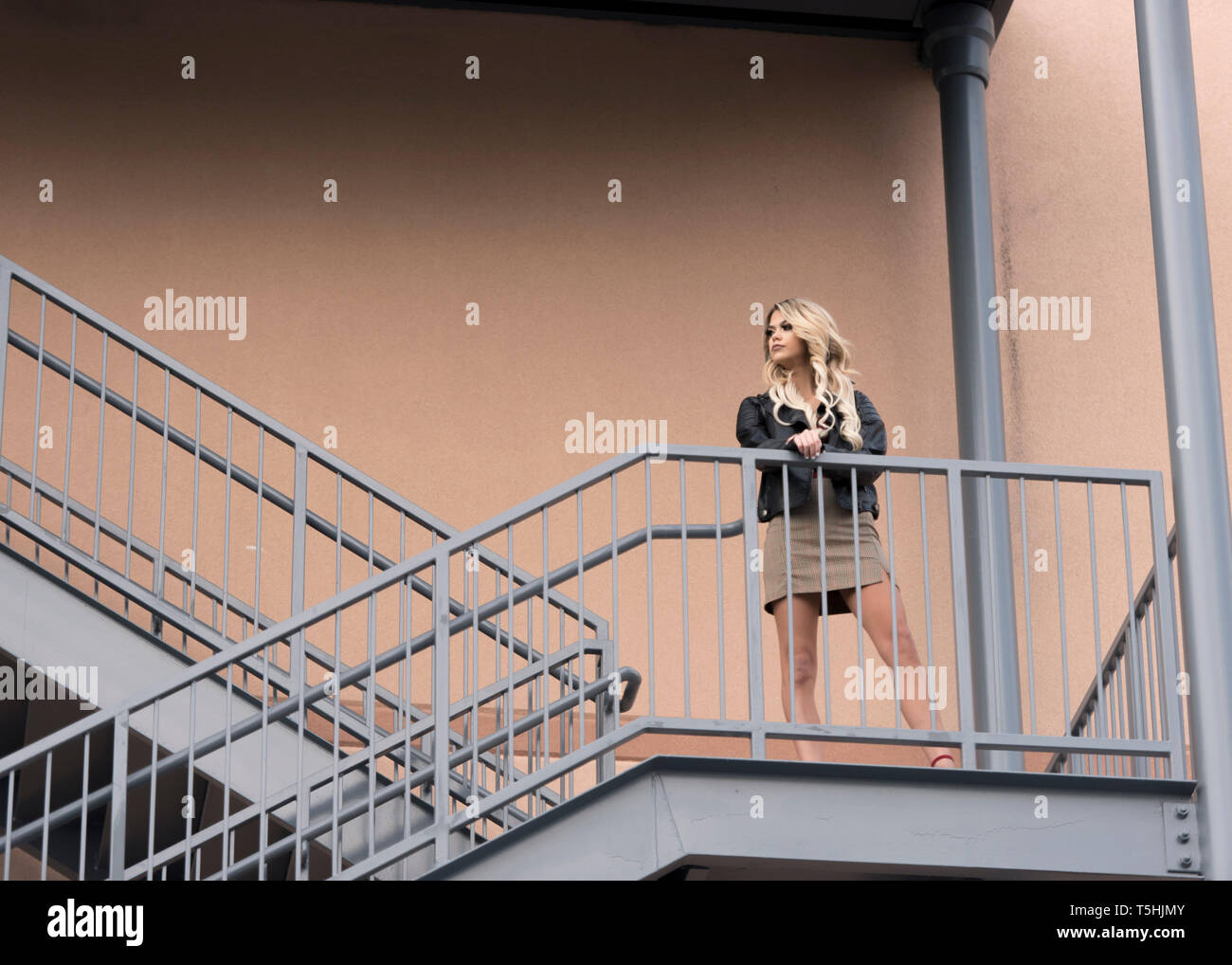 Pretty girl standing on the stairs Stock Photo - Alamy