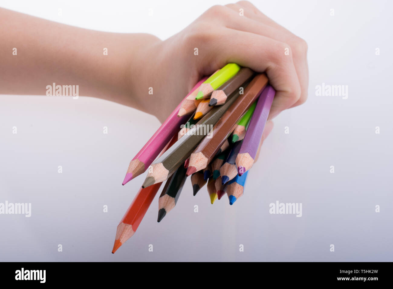 Hand holding color pencils on a white background Stock Photo - Alamy