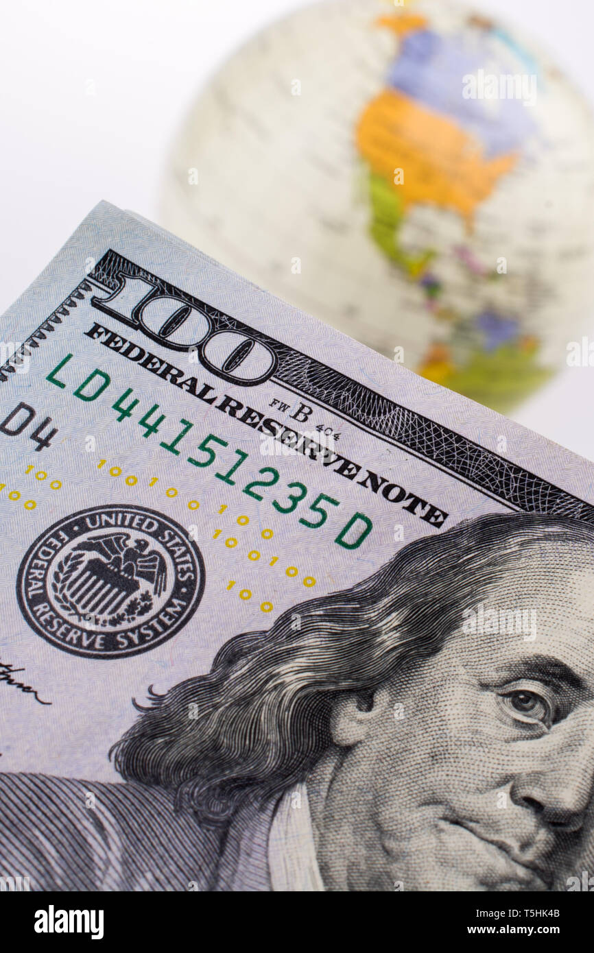 American dollar banknotes by the side of a model globe on white ...