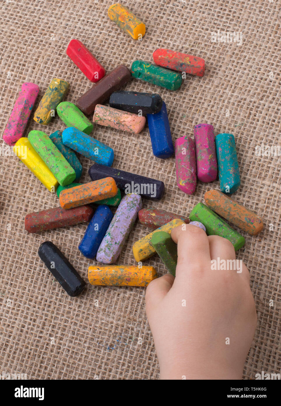 Used color crayons and a toddlers hand holding one Stock Photo - Alamy