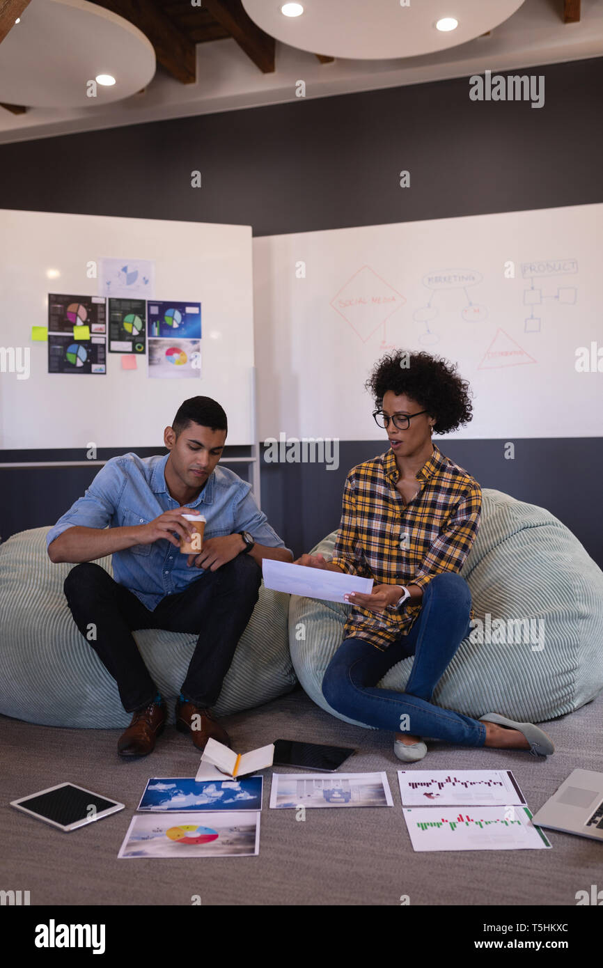 Business people discussing over graph in office Stock Photo - Alamy
