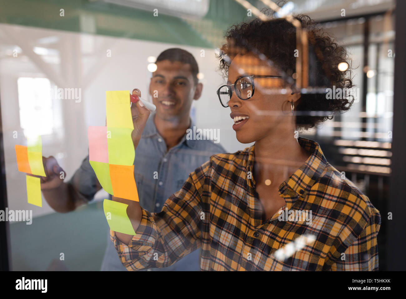Business people writing on sticky notes in office Stock Photo - Alamy