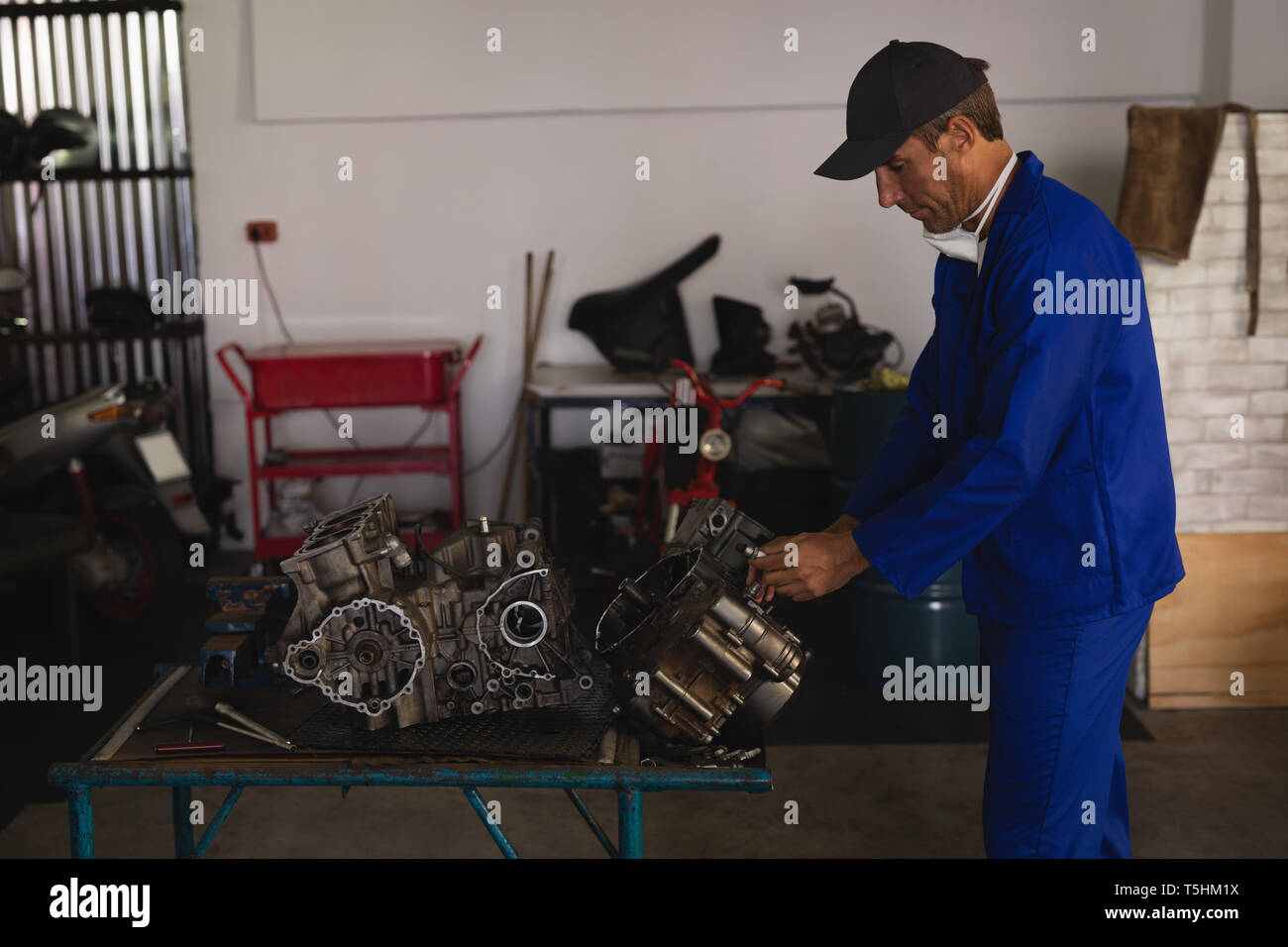 Bike mechanic repairing engine in garage Stock Photo - Alamy