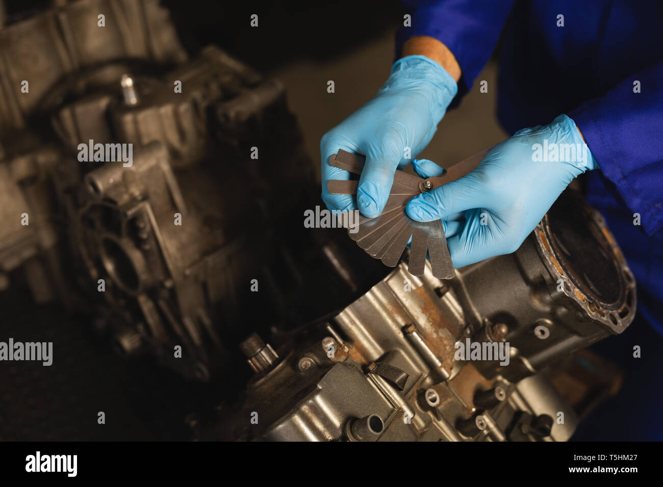 Bike mechanic repairing bike engine in garage Stock Photo - Alamy