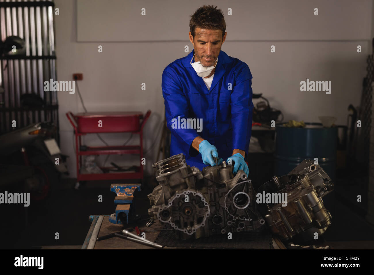 Bike mechanic repairing bike engine in garage Stock Photo - Alamy