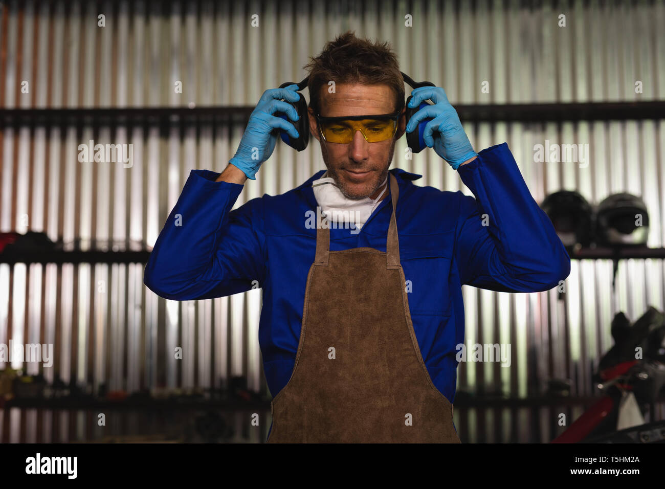 Bike mechanic listening music while working in garage Stock Photo - Alamy