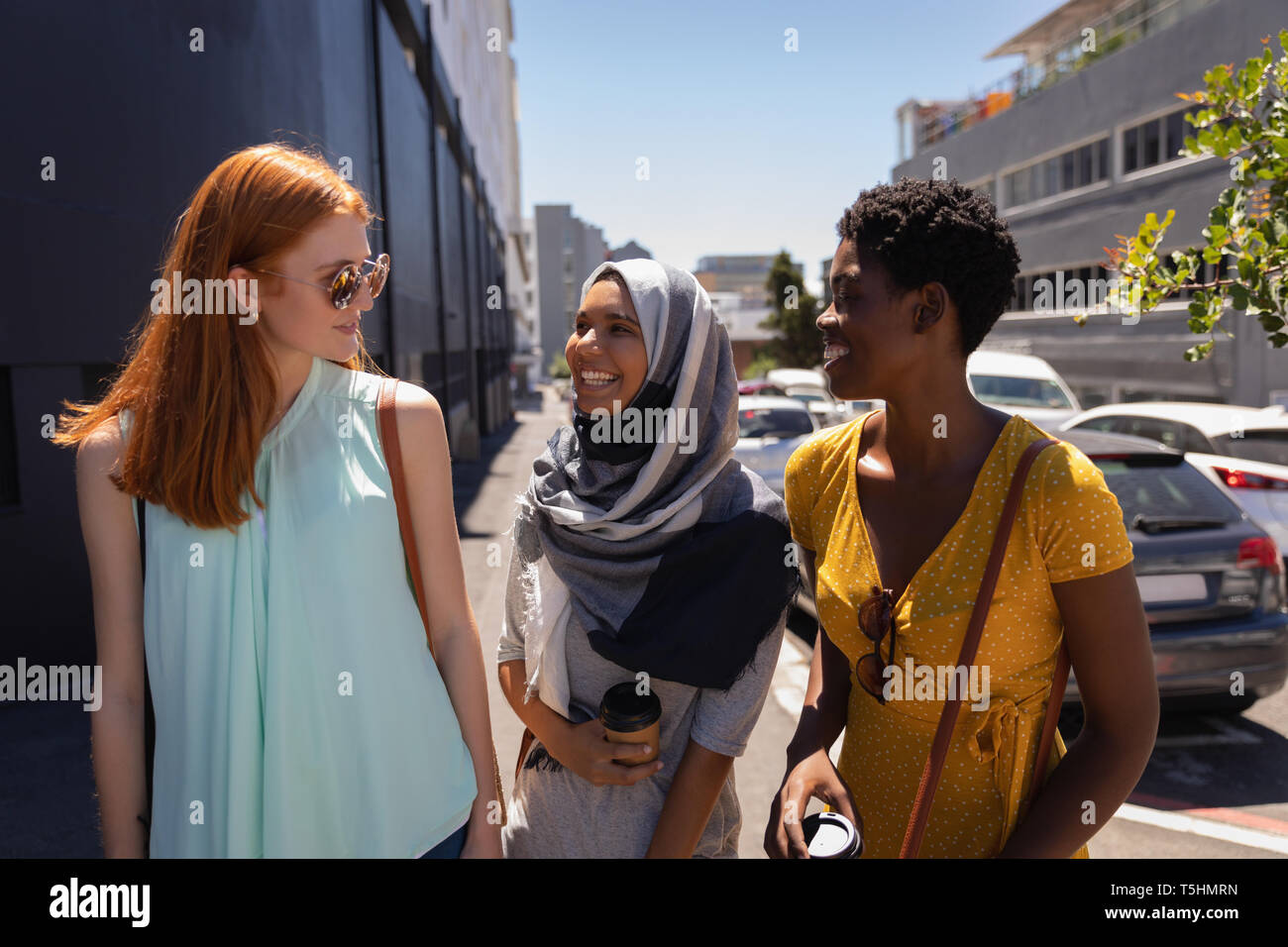 Female friends interacting with each other in the city street Stock ...