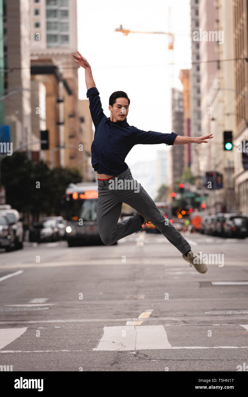 Handsome man jumping and dancing on street Stock Photo - Alamy