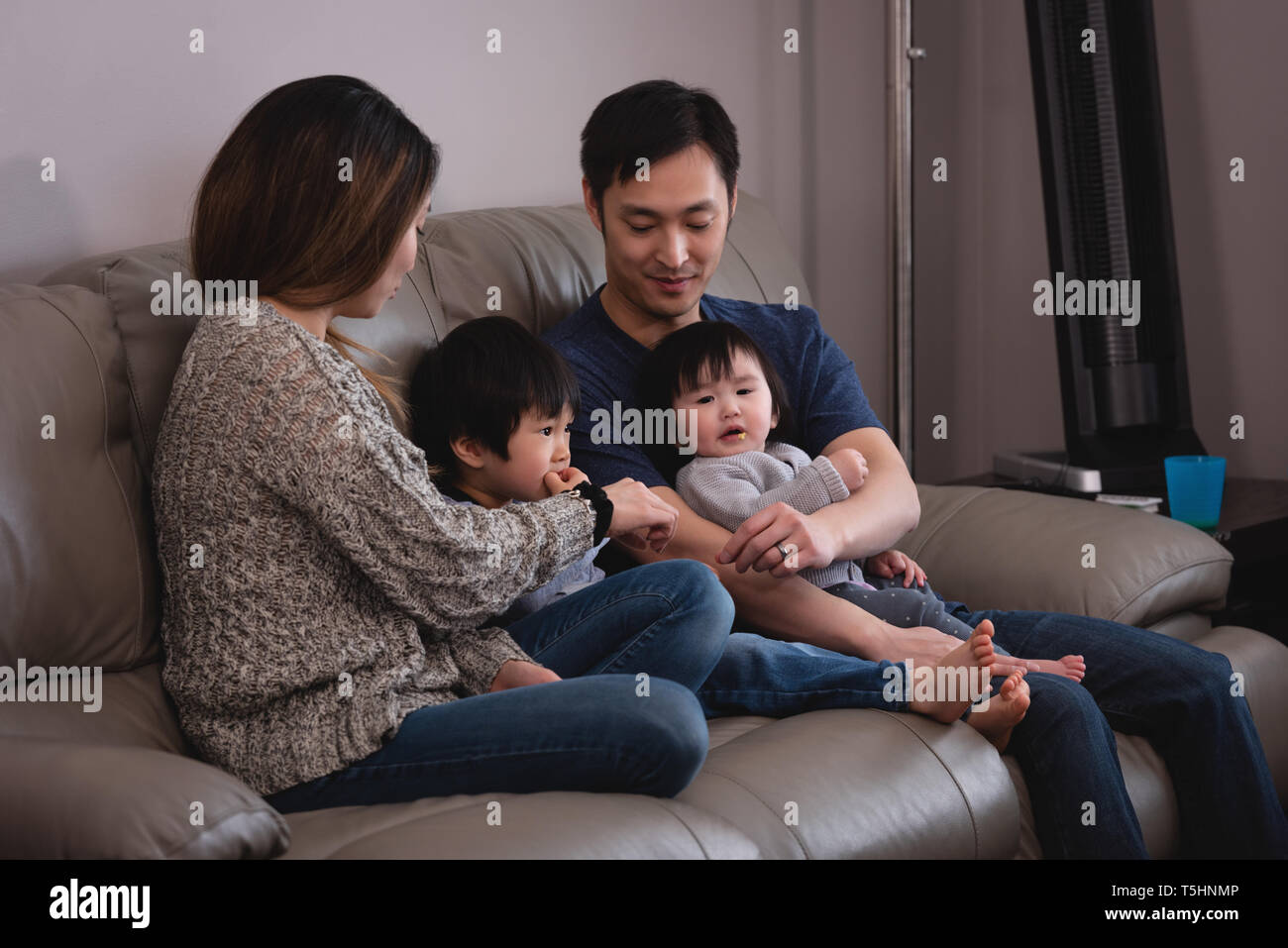 Family sitting on sofa at home Stock Photo - Alamy