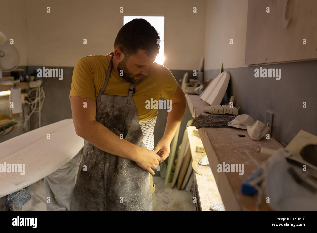 Man wearing apron in a workshop Stock Photo - Alamy