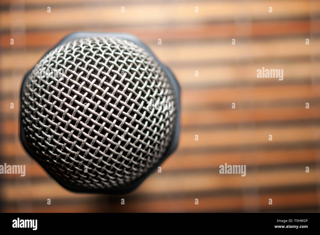 Top-Down View of A Microphone Head and Silver Grille on A Striped ...